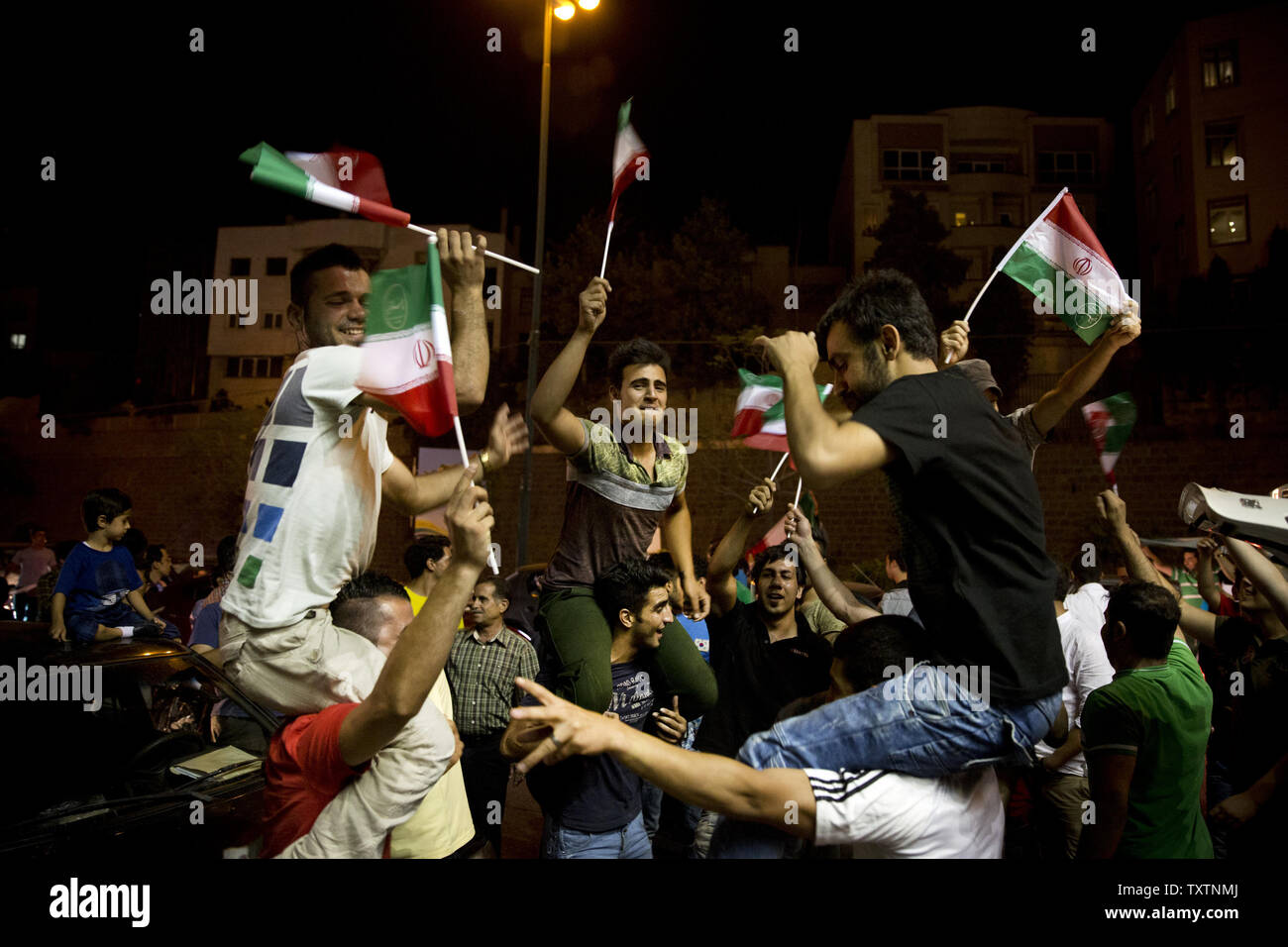 Soccer fans hold Iranian flags as they dance on streets of Tehran, Iran ...