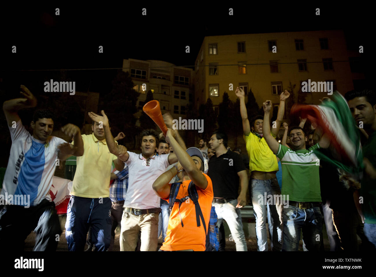 Soccer fans hold Iranian flags as they dance on streets of Tehran, Iran ...