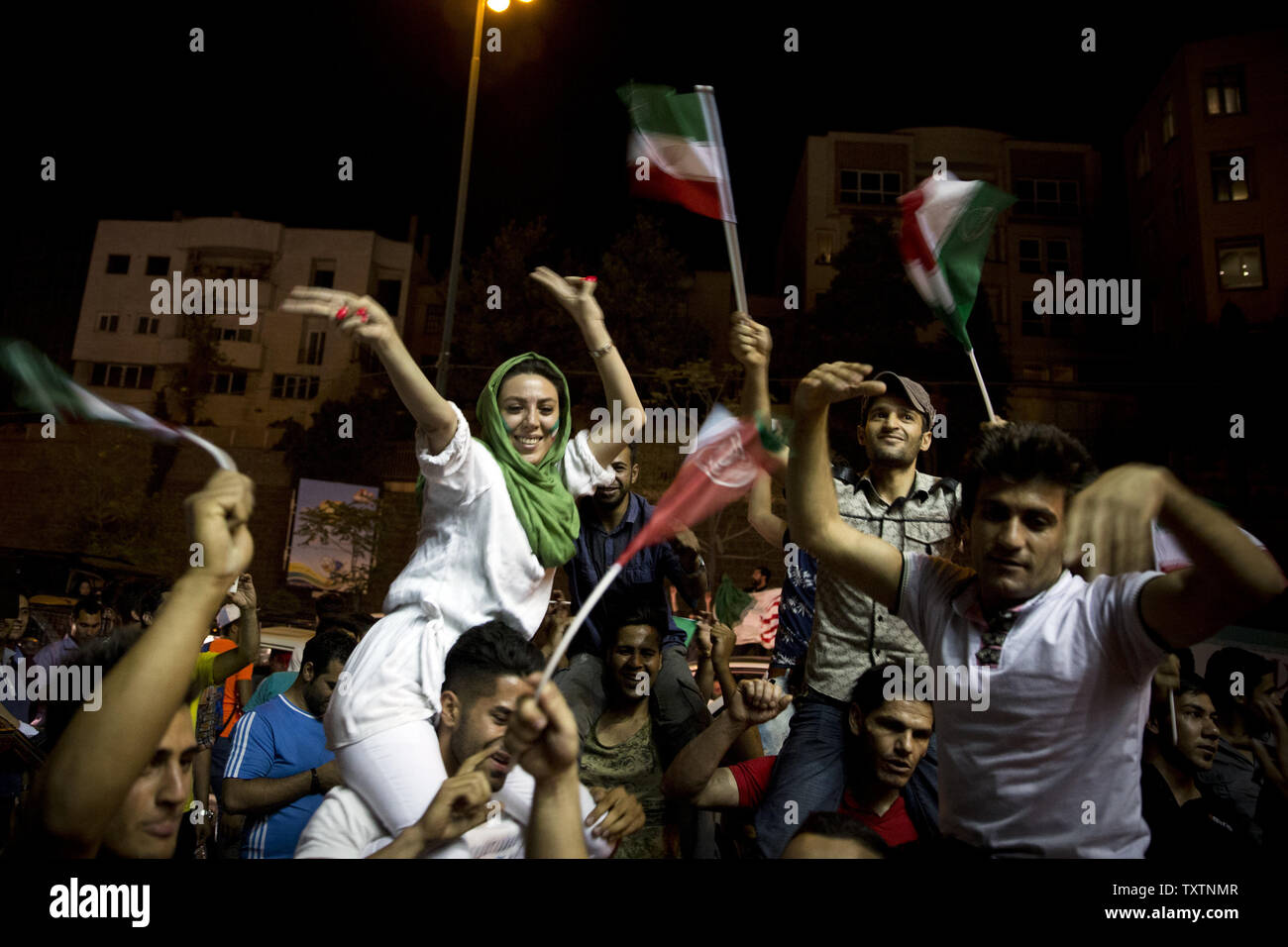 Soccer fans hold Iranian flags as they dance on streets of Tehran, Iran ...