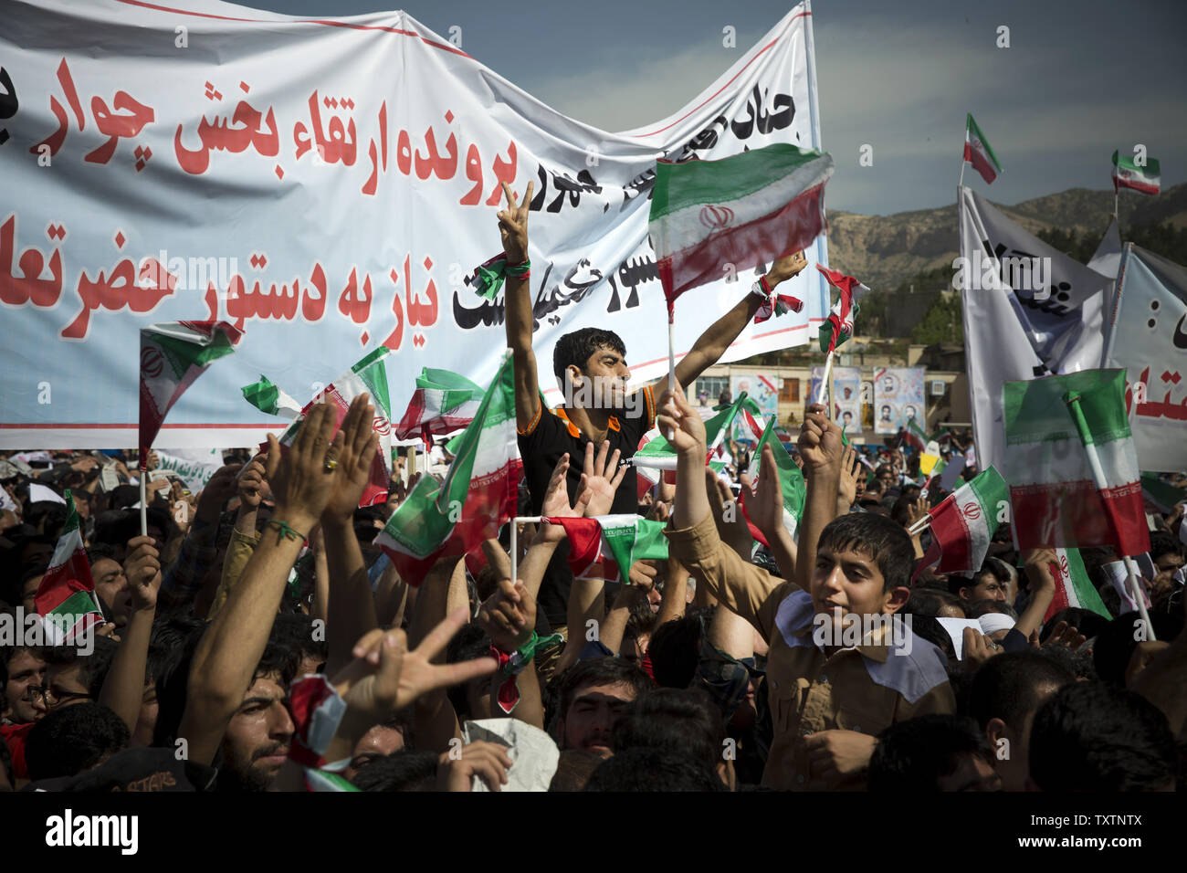 Supporters of Iranian President Hassan Rouhani wave Iranian flags as ...