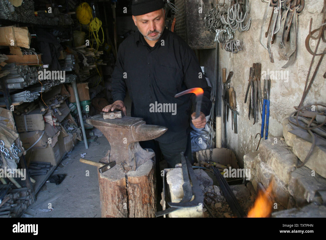 A Shiite blacksmith makes a knife during a muslim ritual as part of ...