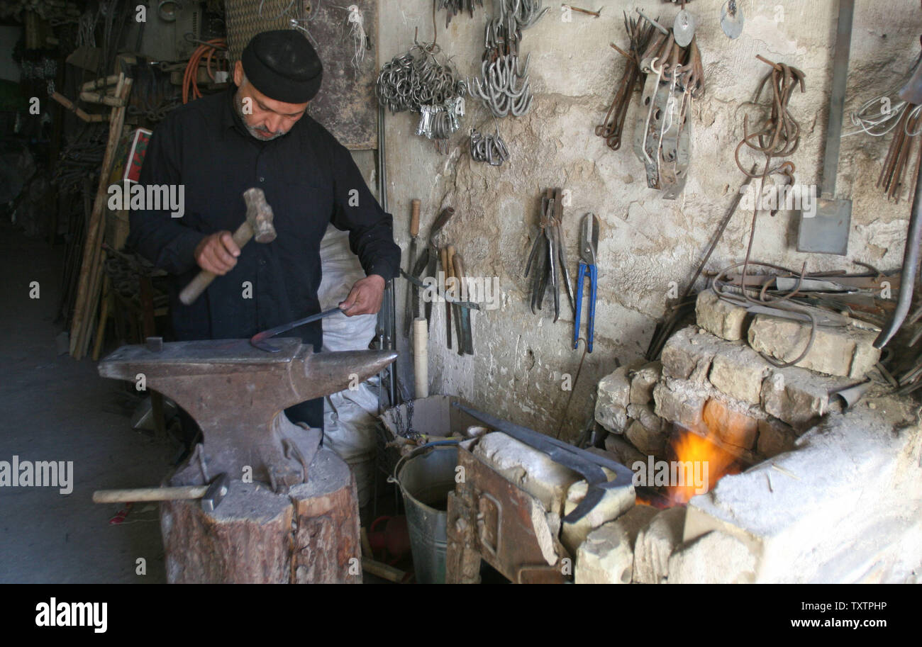 A Shiite blacksmith makes a knife during a muslim ritual as part of ...
