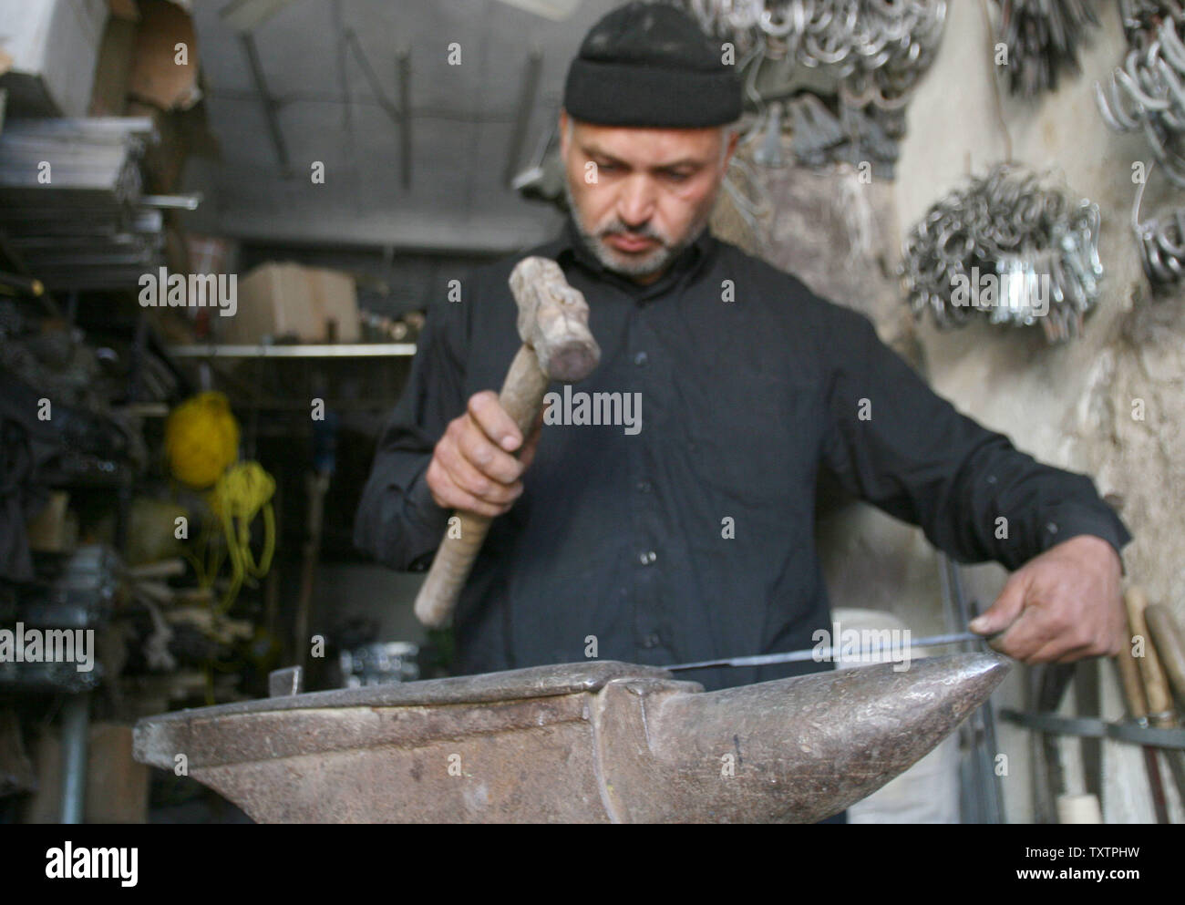 A Shiite blacksmith makes a knife during a muslim ritual as part of ...