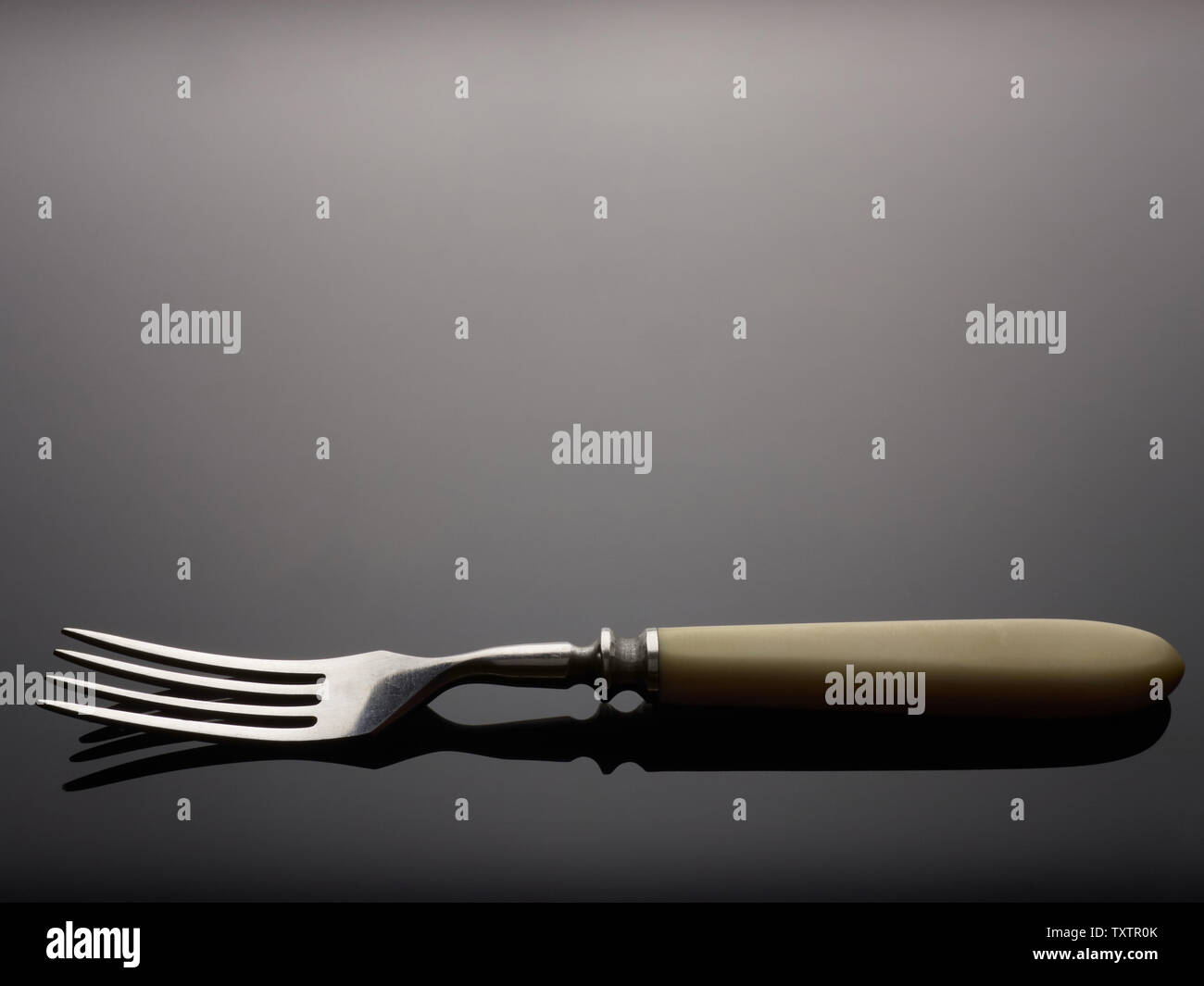 One fork on gray background with gradient and reflection Stock Photo ...