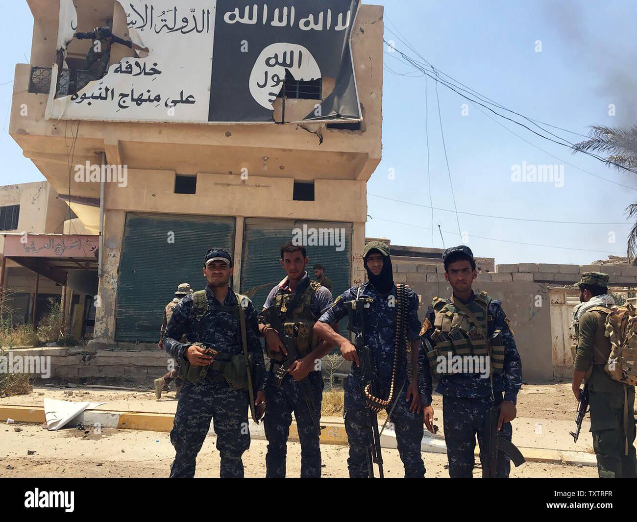 Iraqi security forces and Popular Mobilization Forces, standing while ...