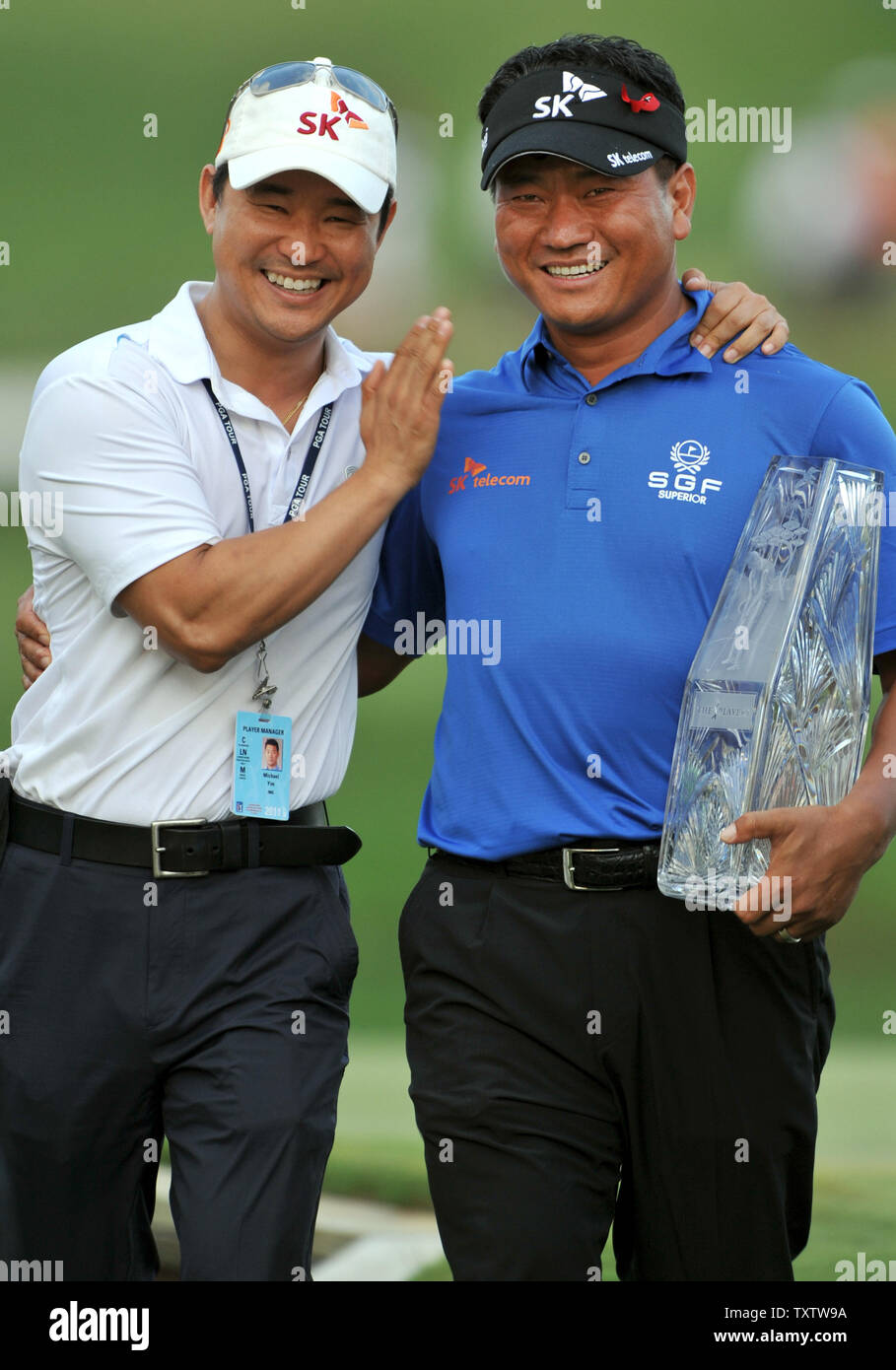K.J. Choi (right) receives a congratulatory pat on the shoulder from ...