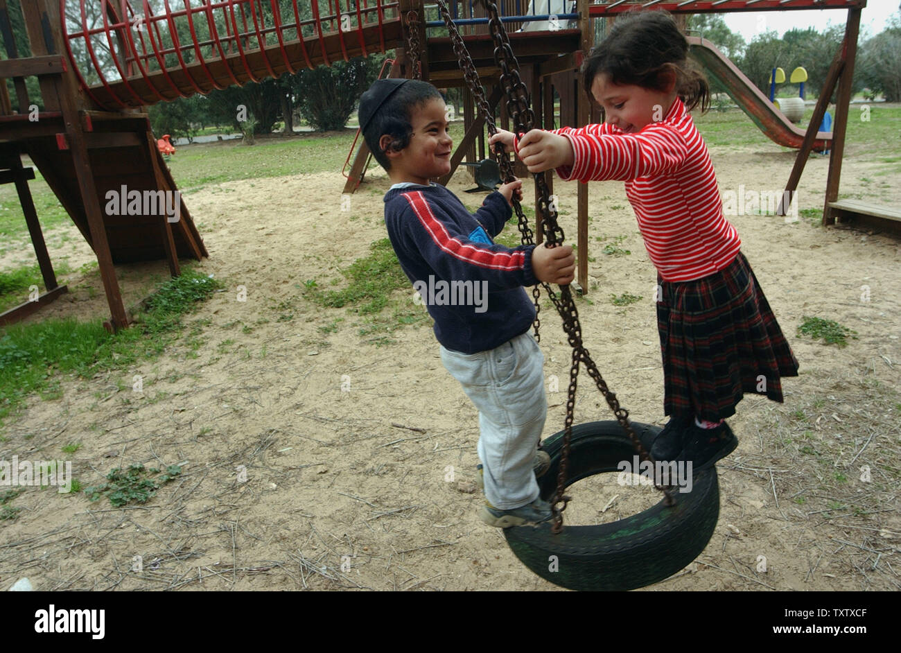 Israeli settler children swing on a playground in the Gaza settlement ...