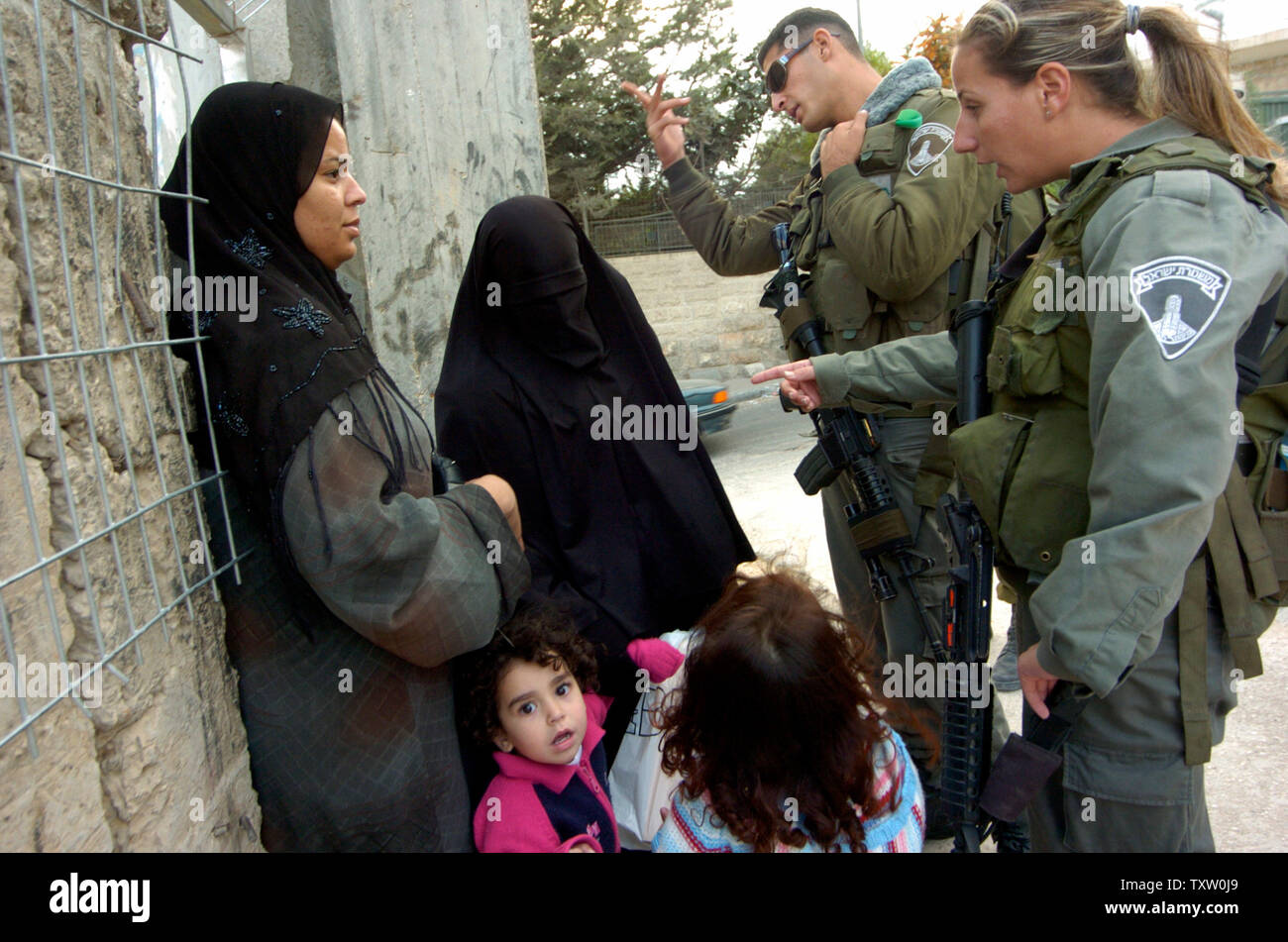 Israeli border police check the identity cards of Palestinians trying ...