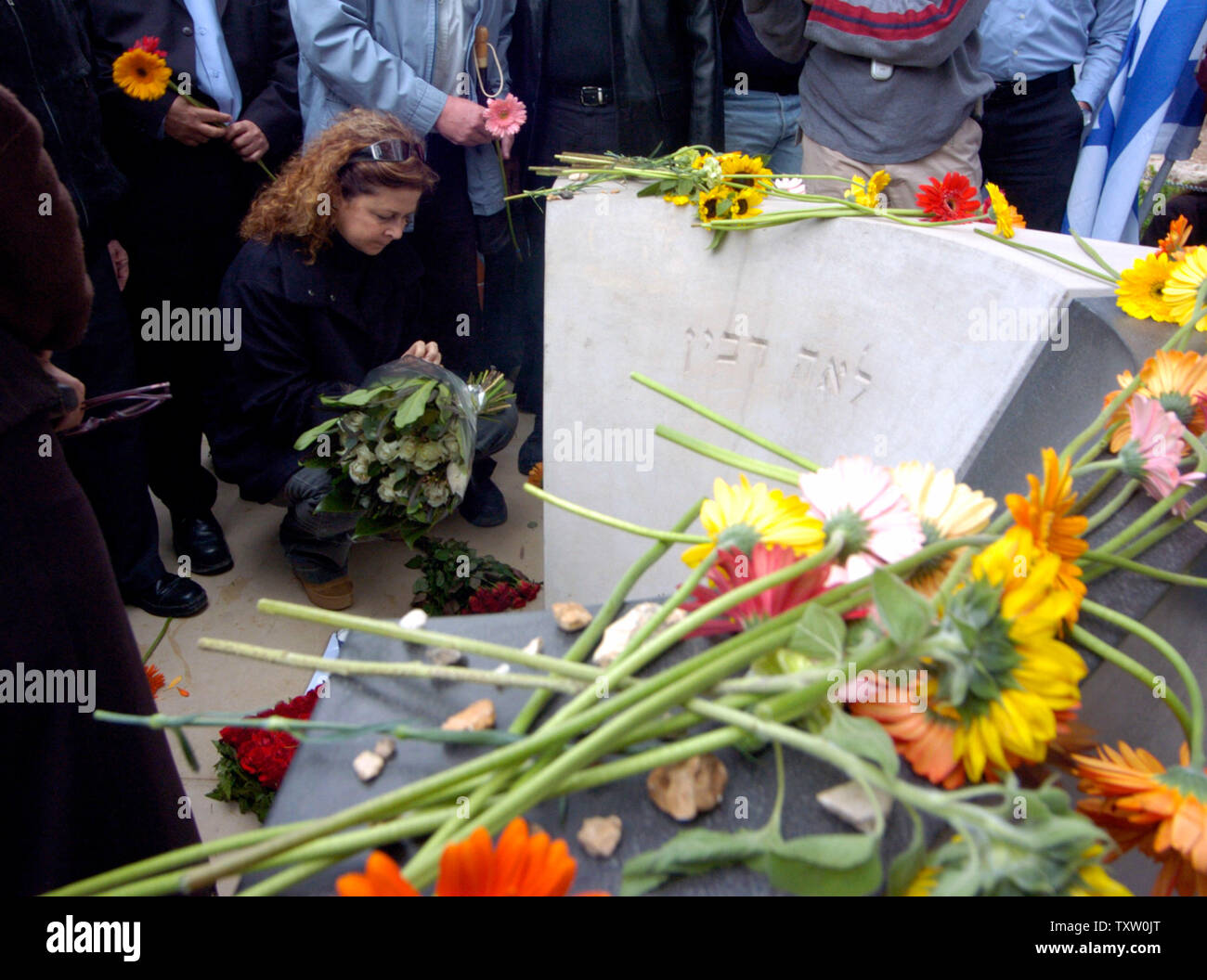 Dalia Rabin-Pelossof kneels by the grave of her father and mother, the ...