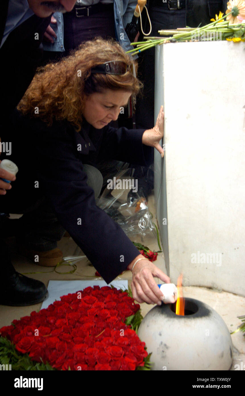 Dalia Rabin-Pelossof lights a candle at the grave of her father and ...