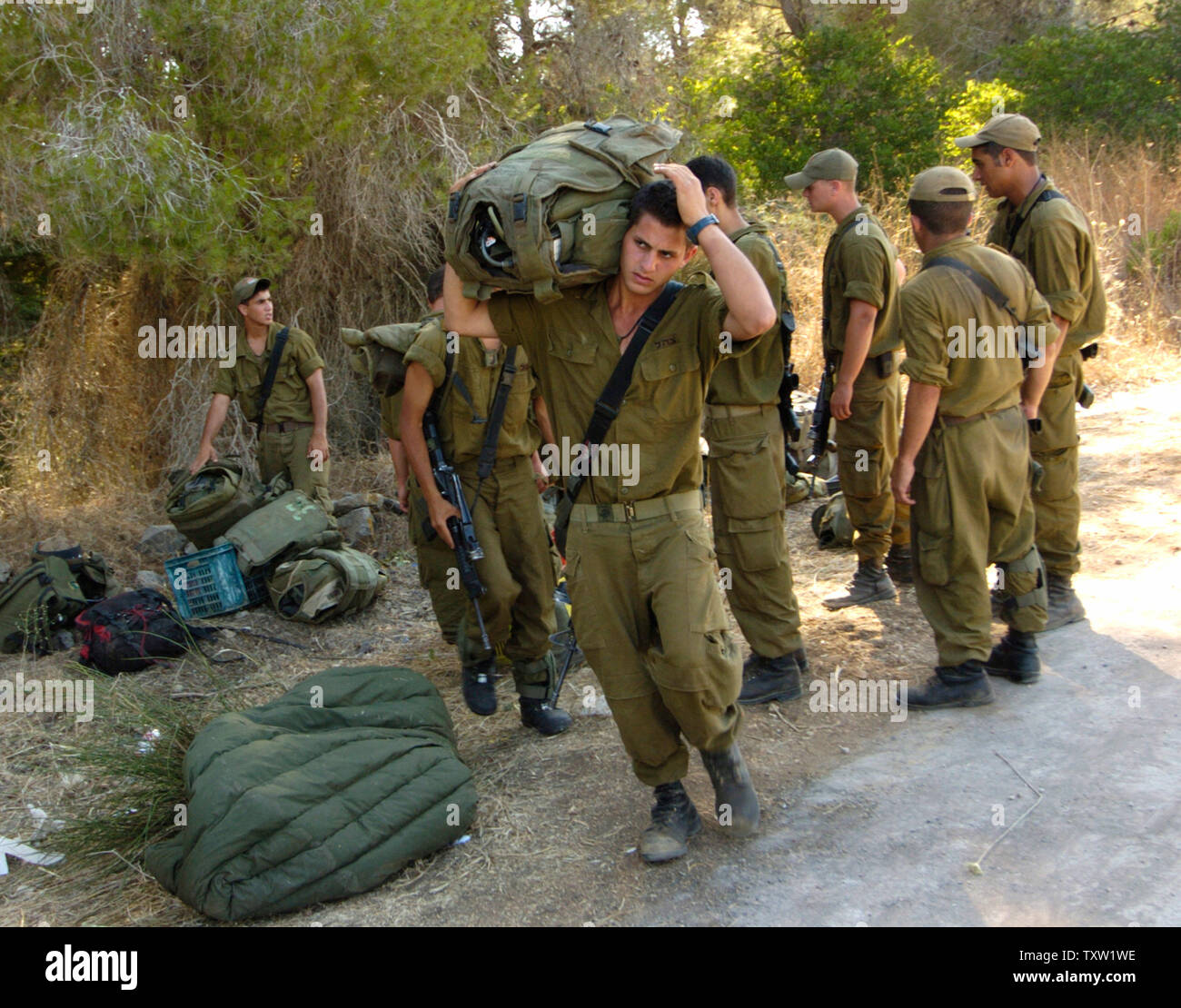 An Israeli soldier carries his body armour to a tank at an Israeli army ...
