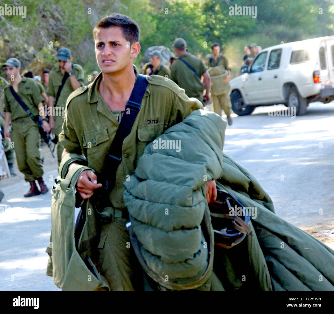 An Israeli soldier carries his gear to a tank at an Israeli army ...