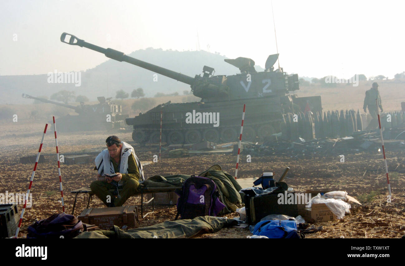 An Israeli soldier prays in the morning near a cannon in an artillery ...