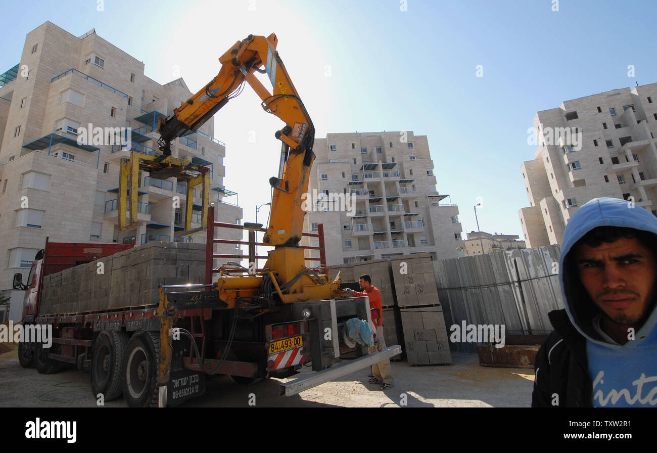 Palestinian construction workers build new housing units in the Israeli ...