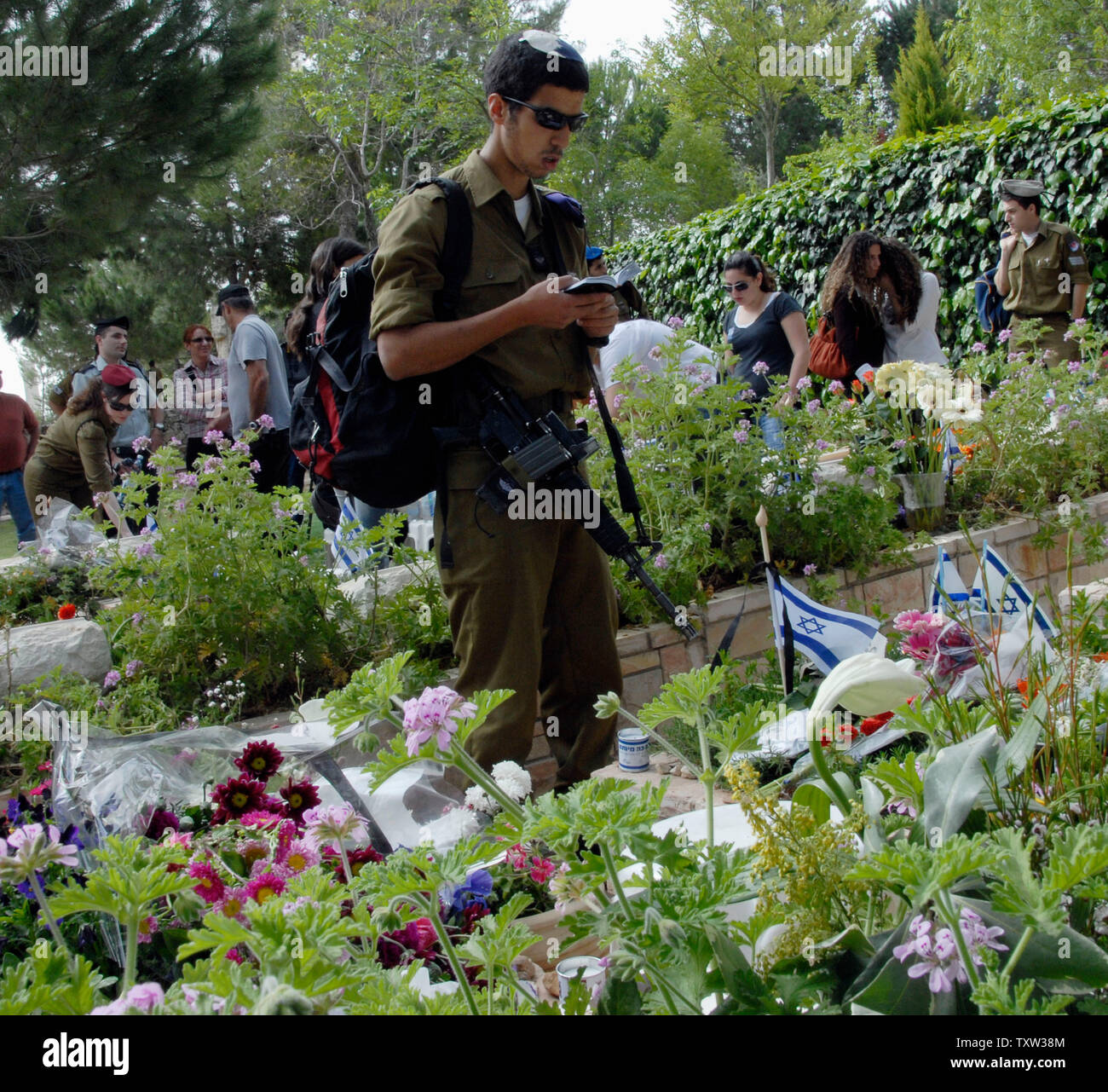 An Israeli soldier prays by graves at the Mt. Herzl Military Cemetery ...