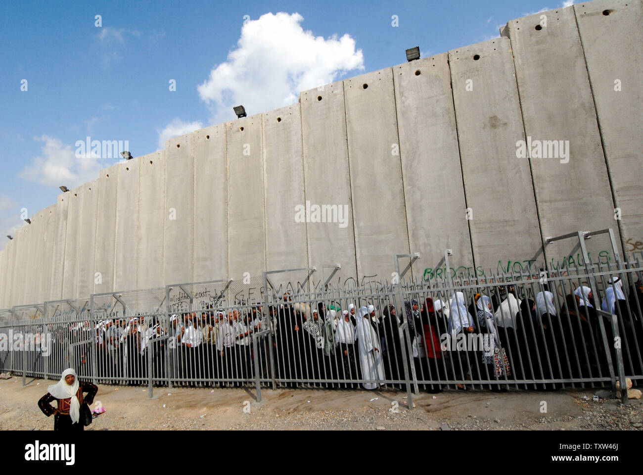 Palestinians wait to cross the Israeli military checkpoint in Bethlehem ...