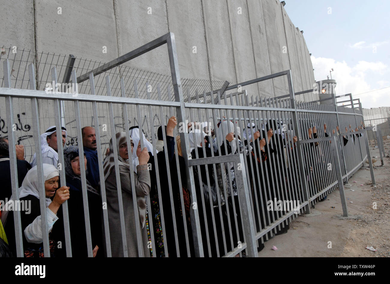 Palestinians wait to cross the Israeli military checkpoint in Bethlehem ...