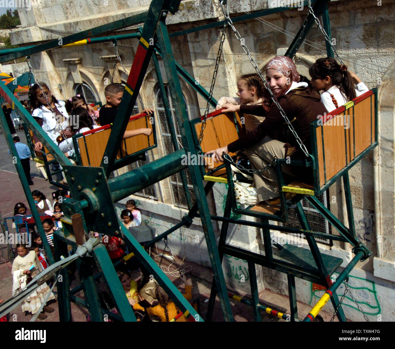 Palestinian youth ride a mini-ferris wheel on the second day of Eid al ...