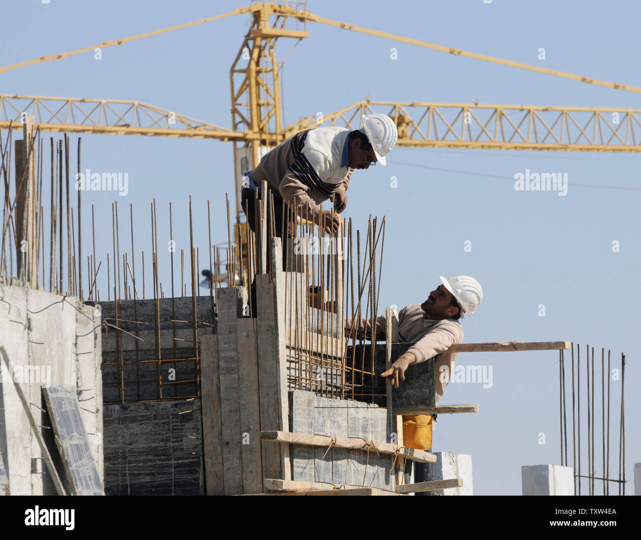 Palestinian construction workers talk while building new apartment ...