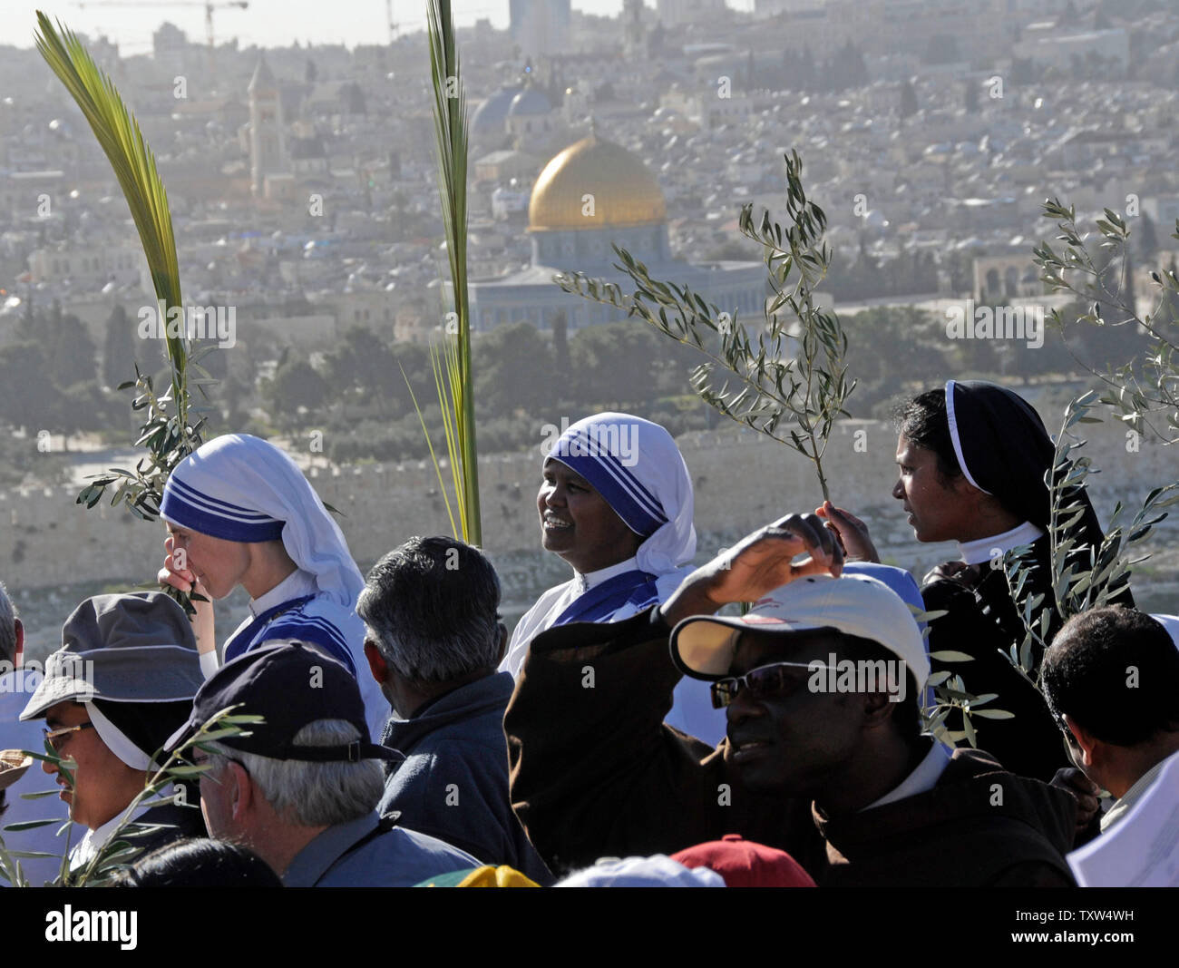 Nuns carry olive and palm branches during the Palm Sunday procession on ...