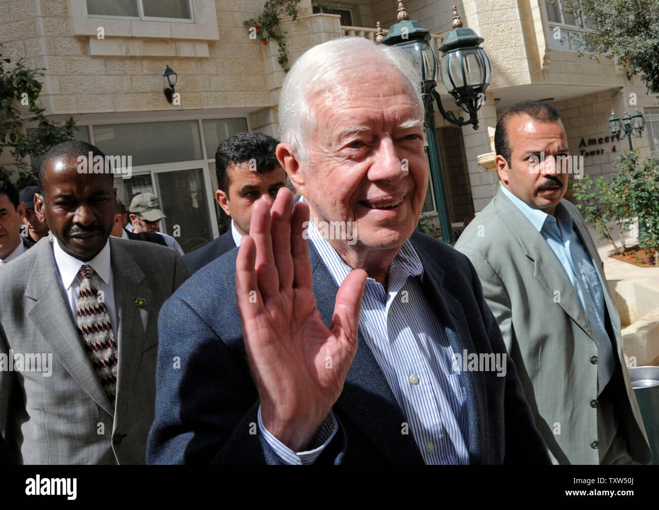 Former U.S. President Jimmy Carter waves to the press after meeting ...