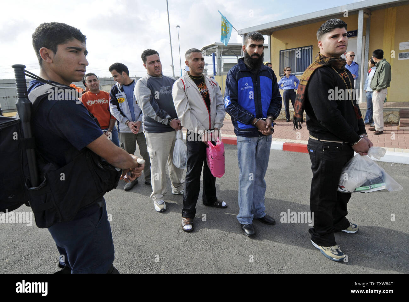 Handcuffed Palestinian security prisoners wait to be processed before ...