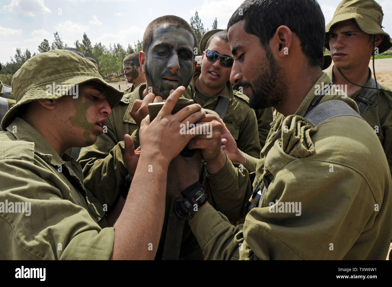 Israeli soldiers from the Givati Brigade apply face paint before ...