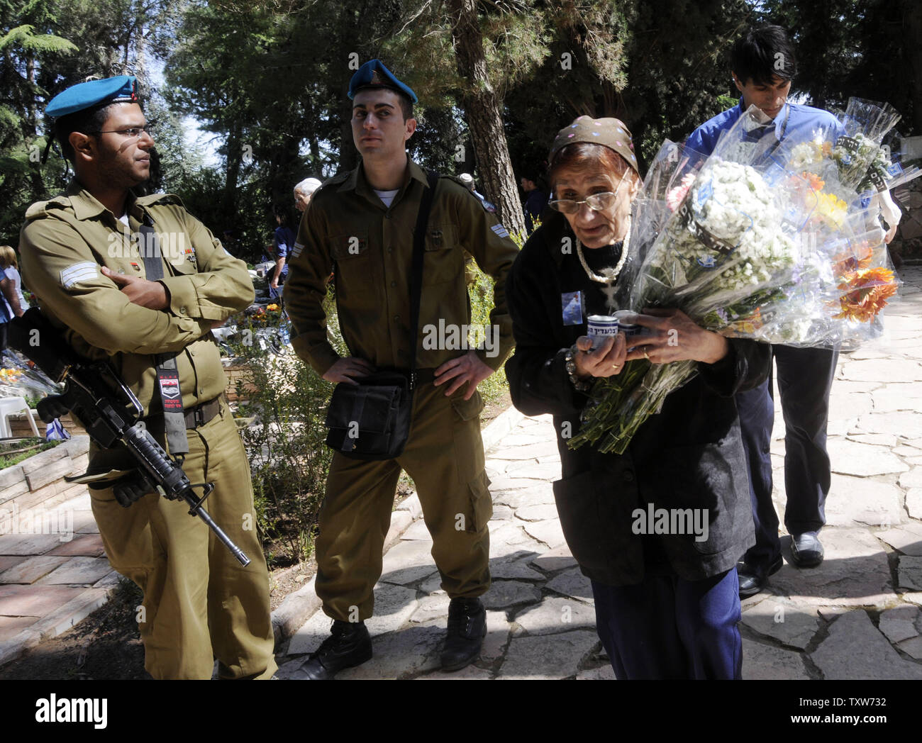 An Israeli woman carries flowers and memorial candles at the Mt. Herzl ...