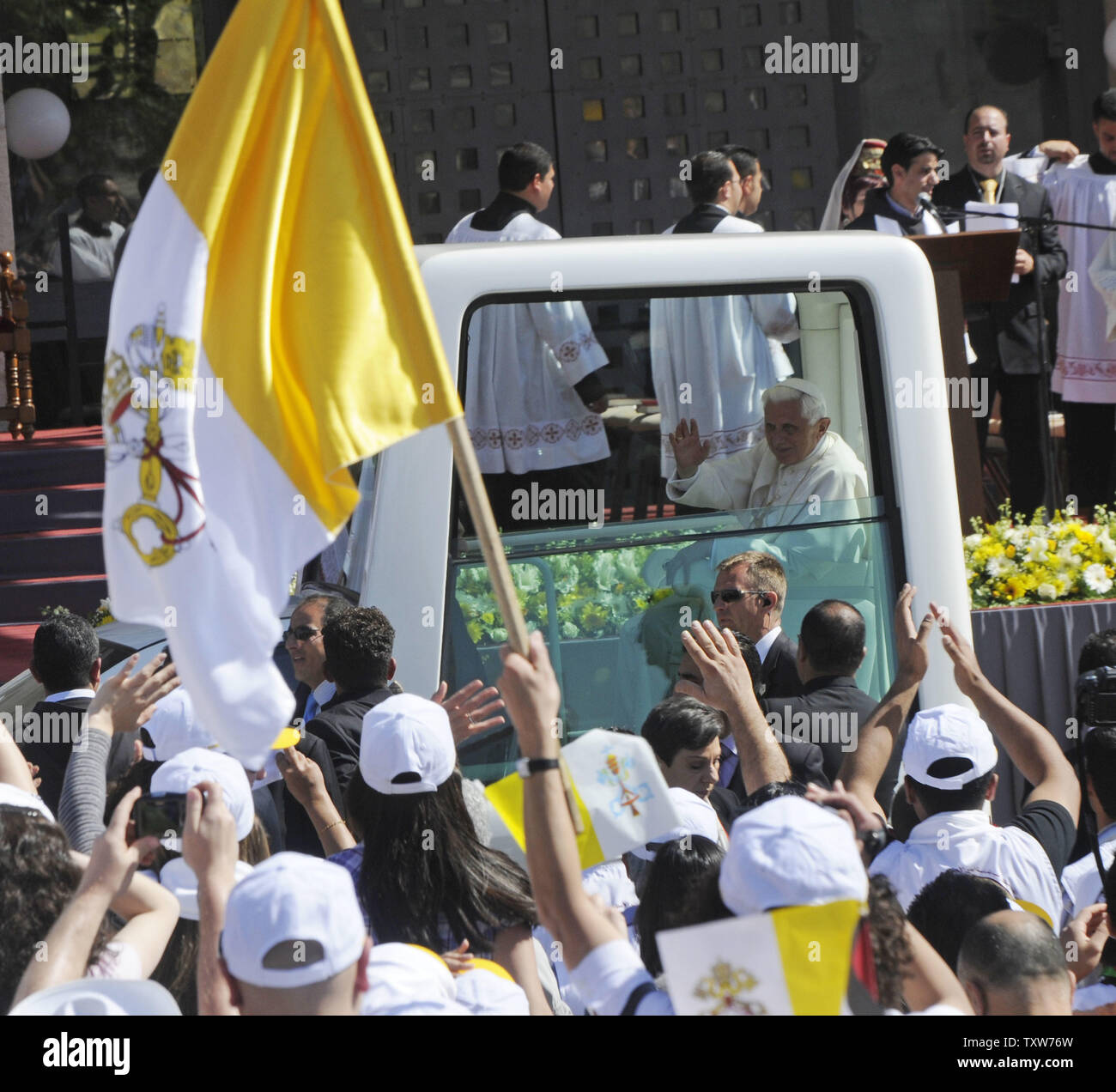 Pope Benedict XVI waves to the crowd from the Popemobile on his arrival ...