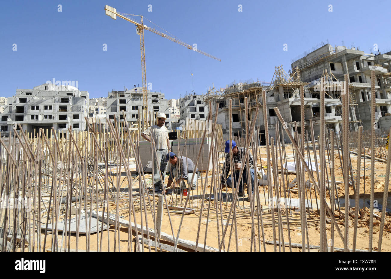 Palestinian construction workers build new homes in the Israeli ...