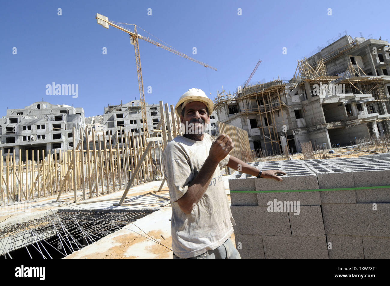 A Palestinian construction worker takes a break from building new homes ...