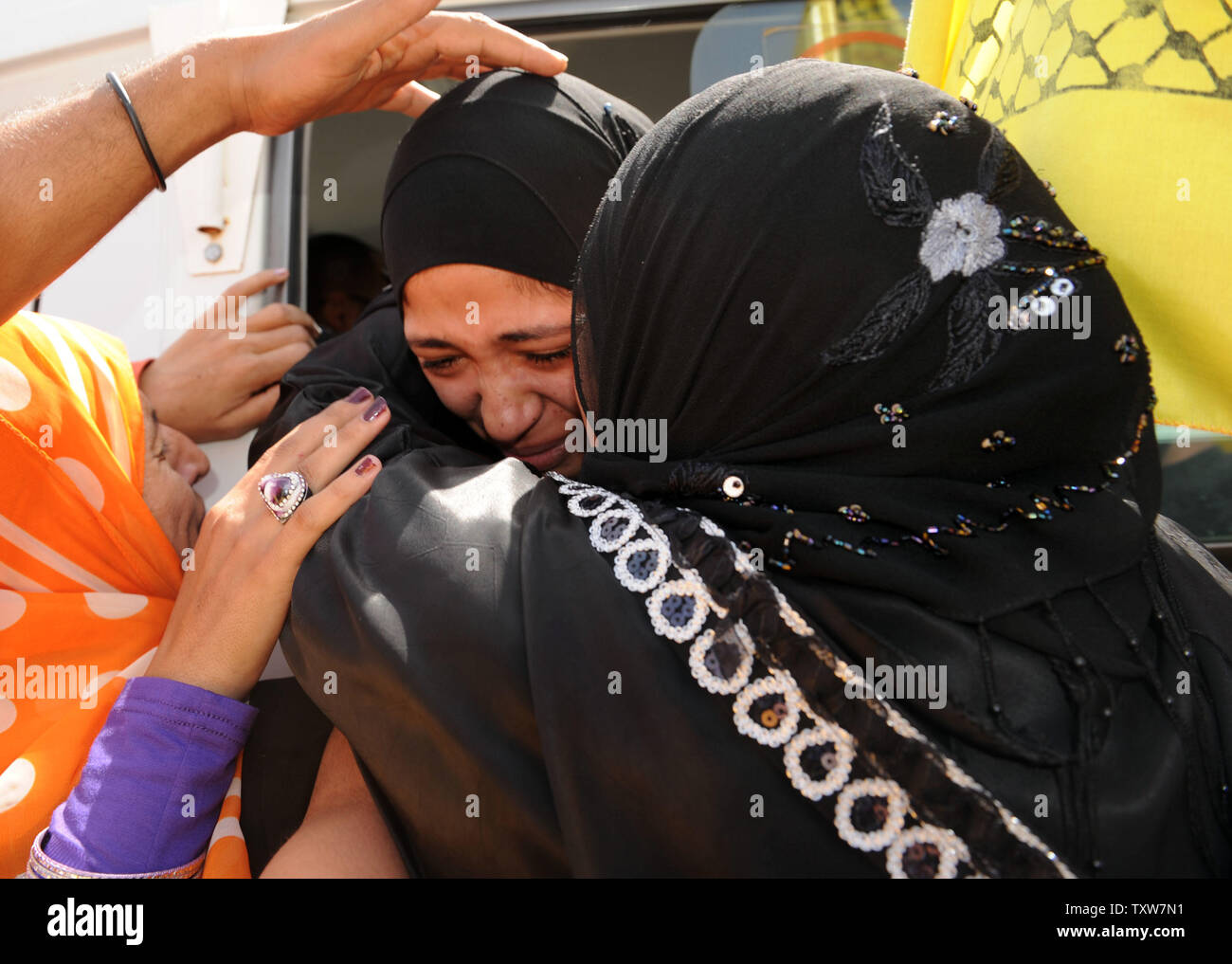 A newly released Palestinian prisoner hugs relatives upon her arrival ...