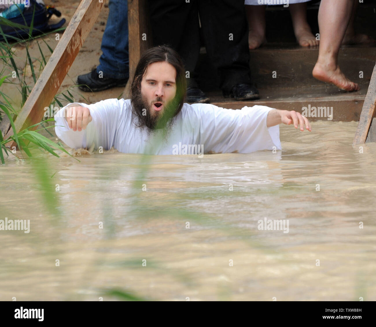 A Greek Orthodox pilgrim goes into the Jordan River on the Jordanian ...