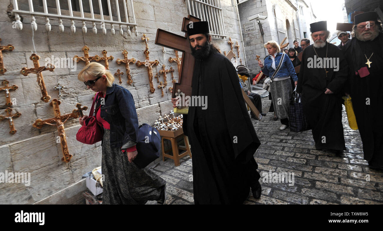 An Orthodox priest carries a cross on the Via Dolorosa, the traditional ...