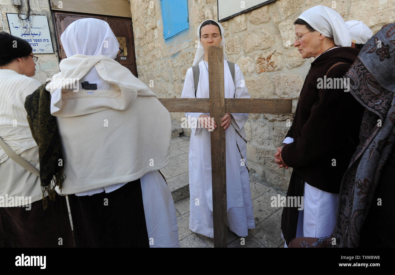 Catholic nuns pray with a cross on the Via Dolorosa, the traditional ...