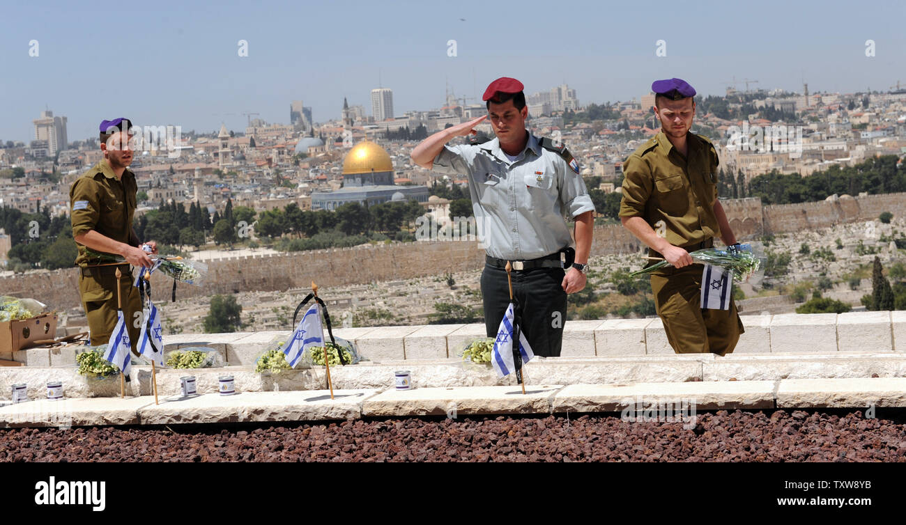 An Israeli officer salutes after placing flowers and an Israeli flag on ...