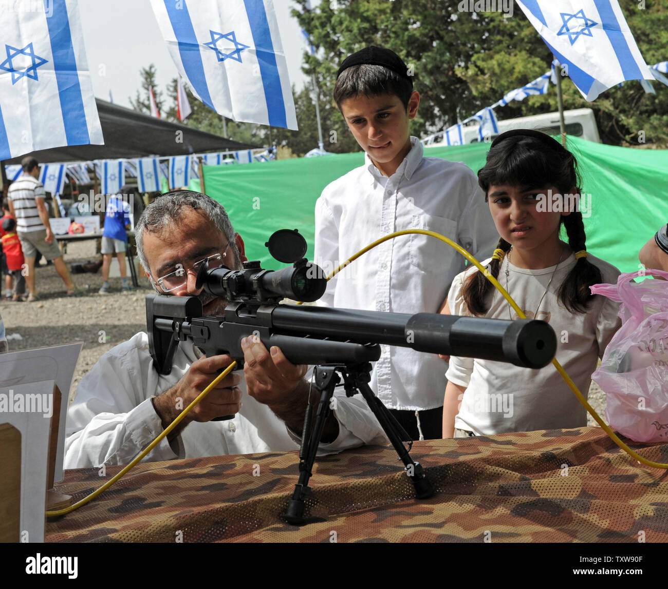 An Israeli man holds an automatic weapon at a military weapons display ...