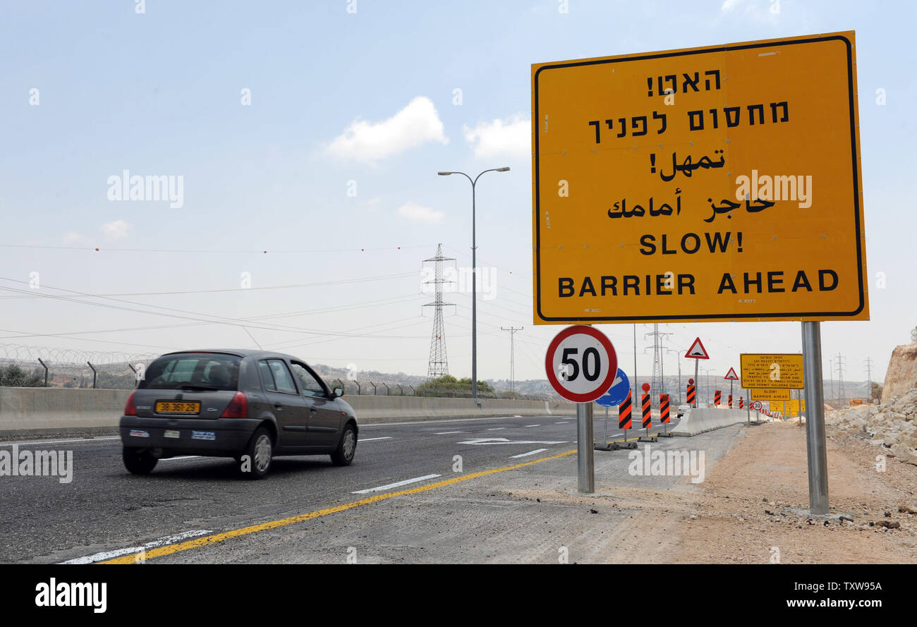 An Israeli road sign cautions drivers to stop at a new military ...