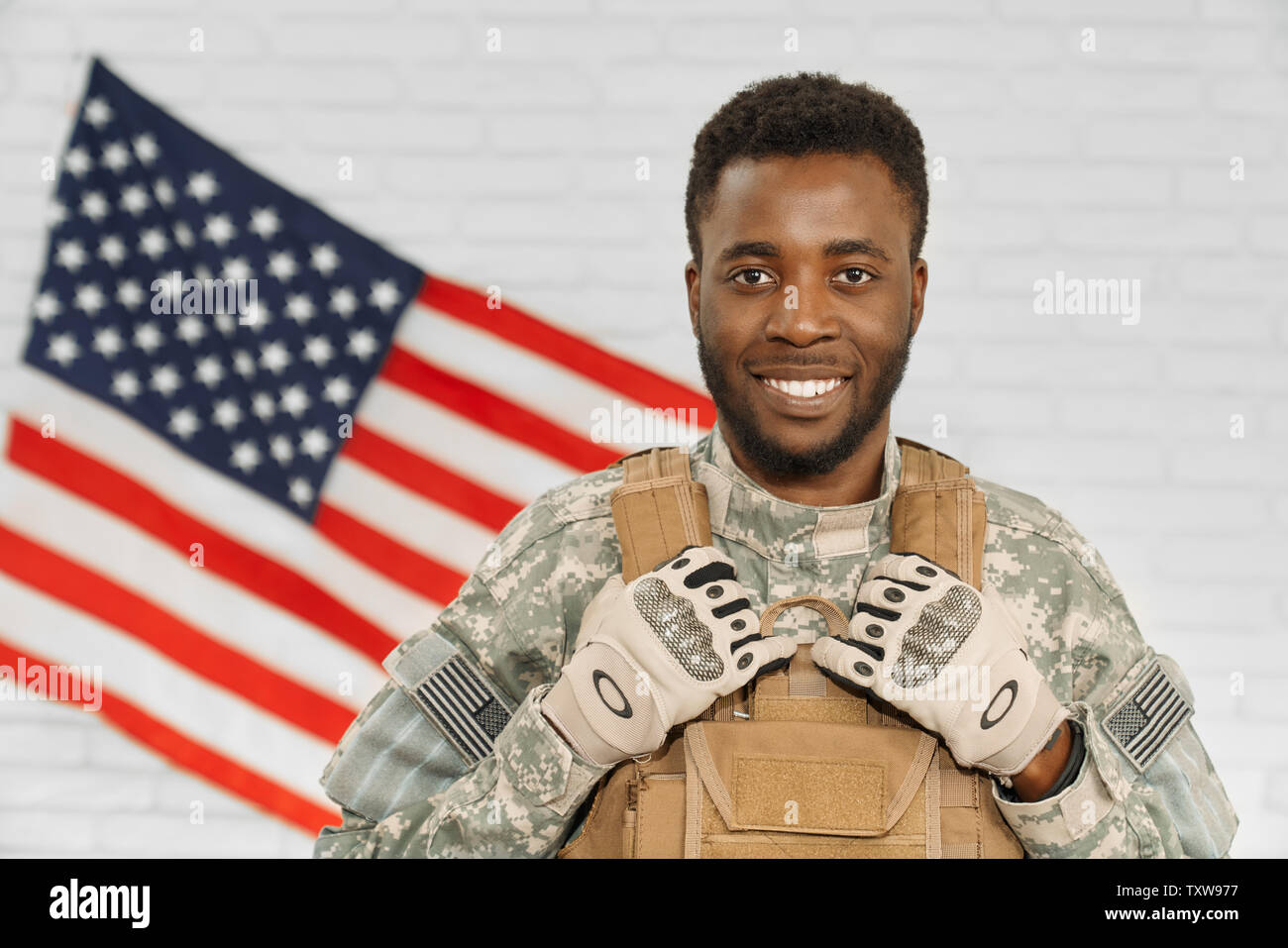 Front view of happy soldier wearing Americans army uniform and armour ...