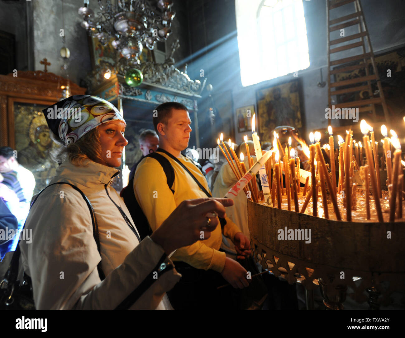Russian pilgrims light candles in the Church of the Nativity, where ...