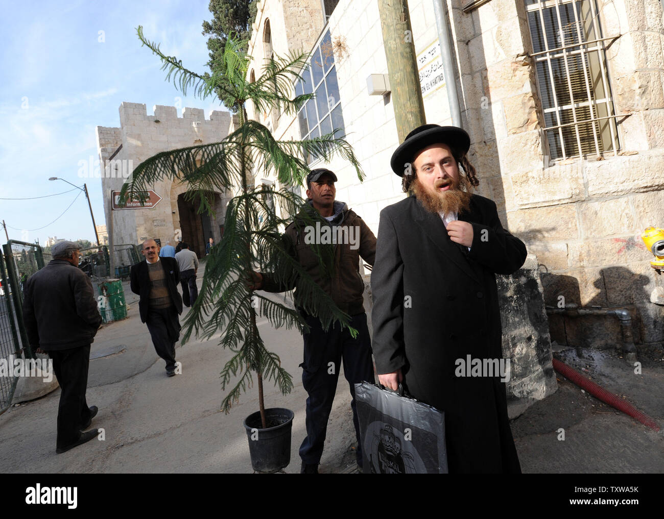 An Ultra-Orthodox rabbi walks in front of a Palestinian Christian ...