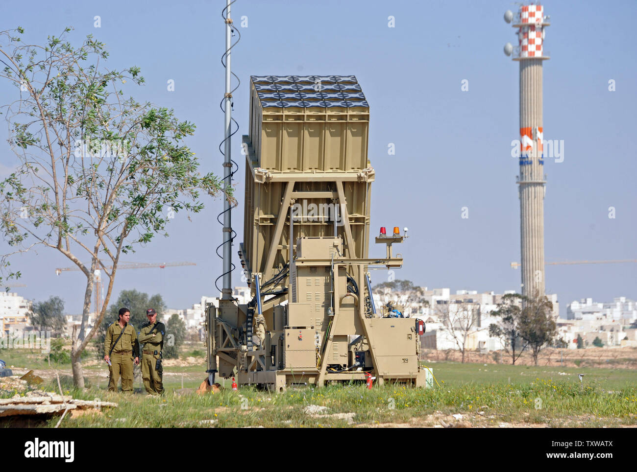 Israeli soldiers stand near the Iron Dome, a new anti-rocket system ...