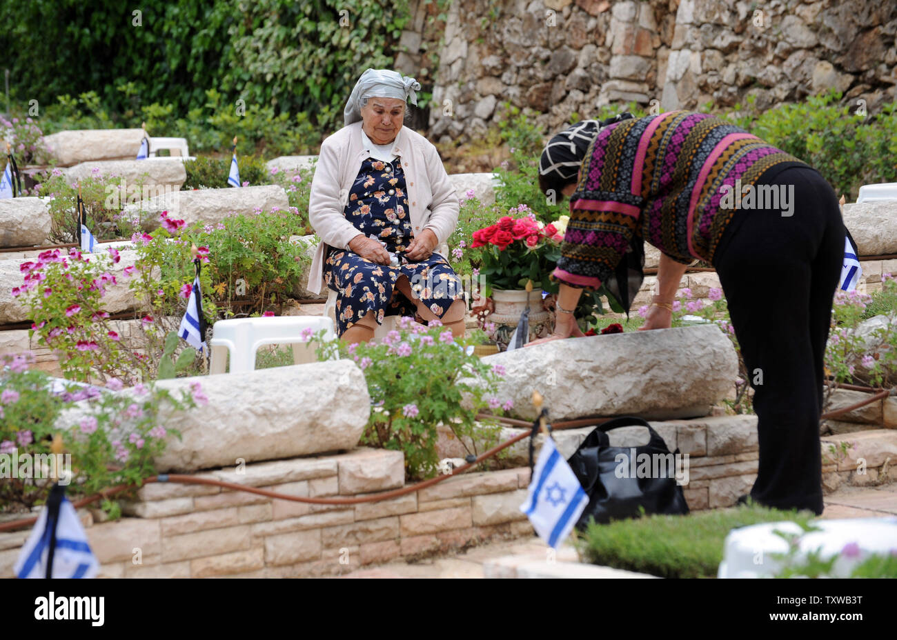 Israeli women mourn by the grave of a relative before the start of the ...