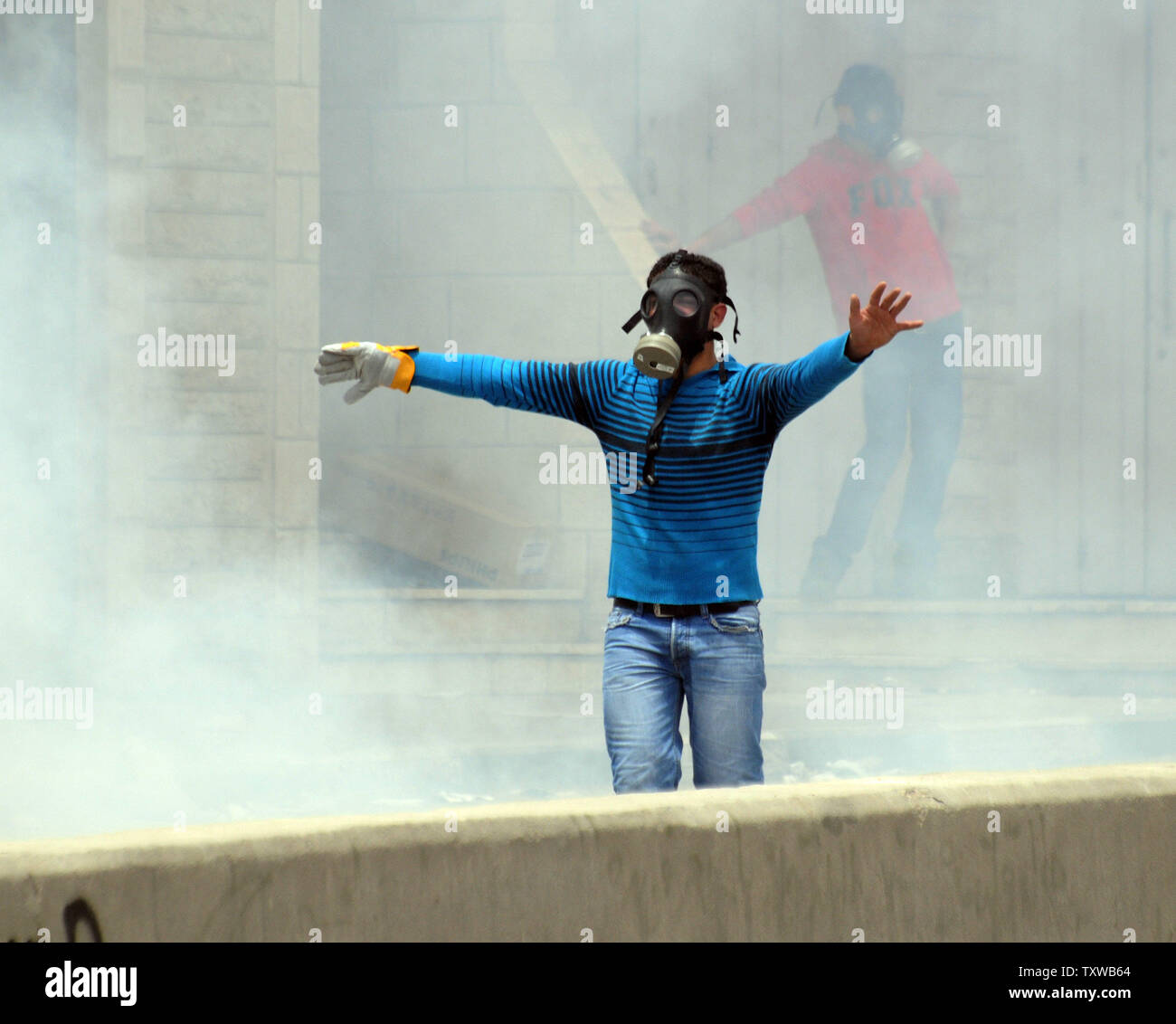 A Palestinian wears a gas mask during clashes with Israeli soldiers ...