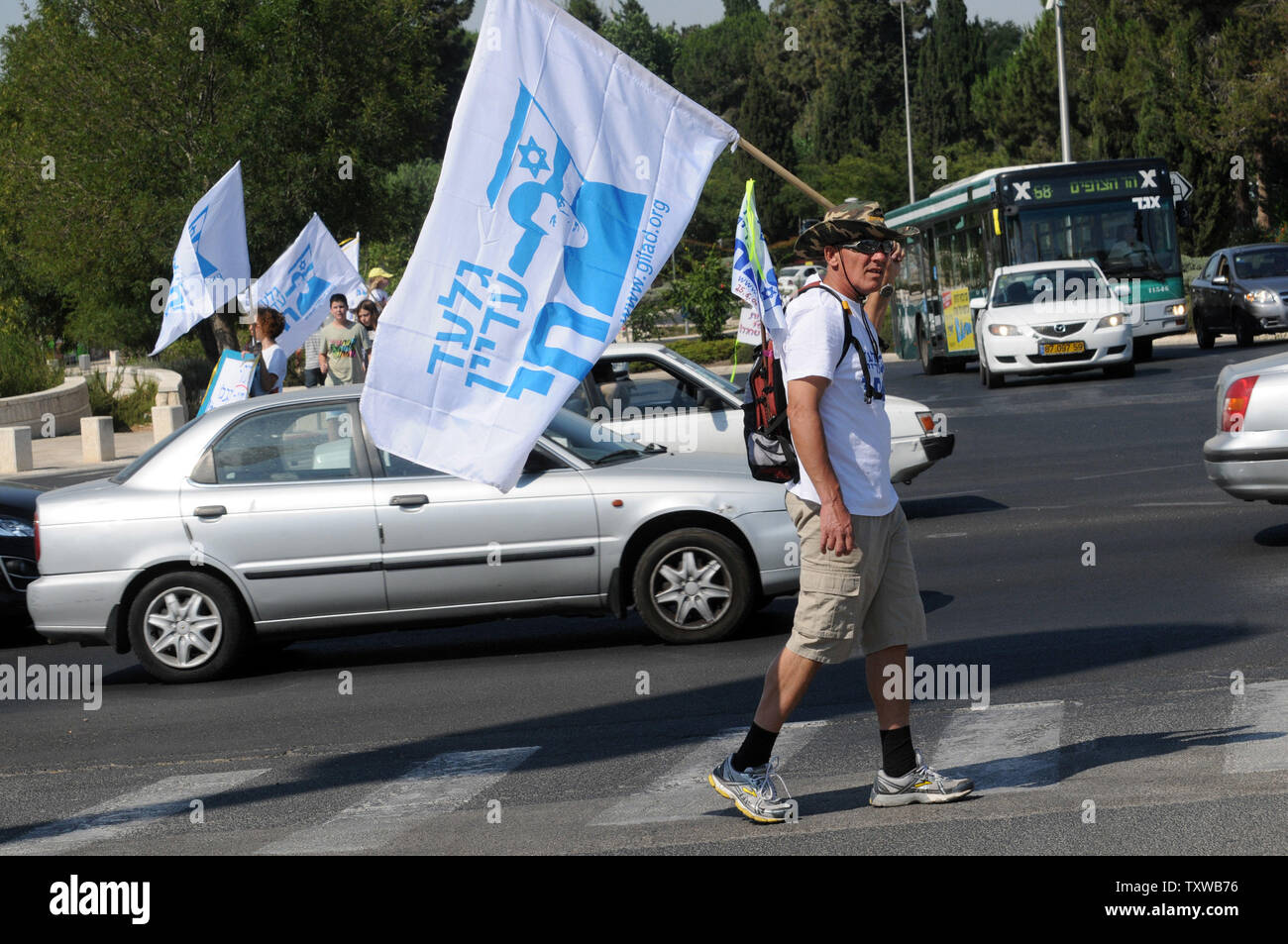 An Israeli carries a flag with the image of captured Israeli soldier ...