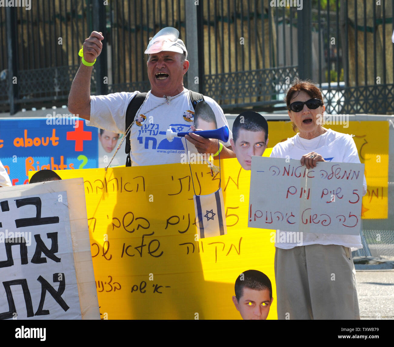 Israelis hold masks with the image of captured Israeli soldier Gilad ...