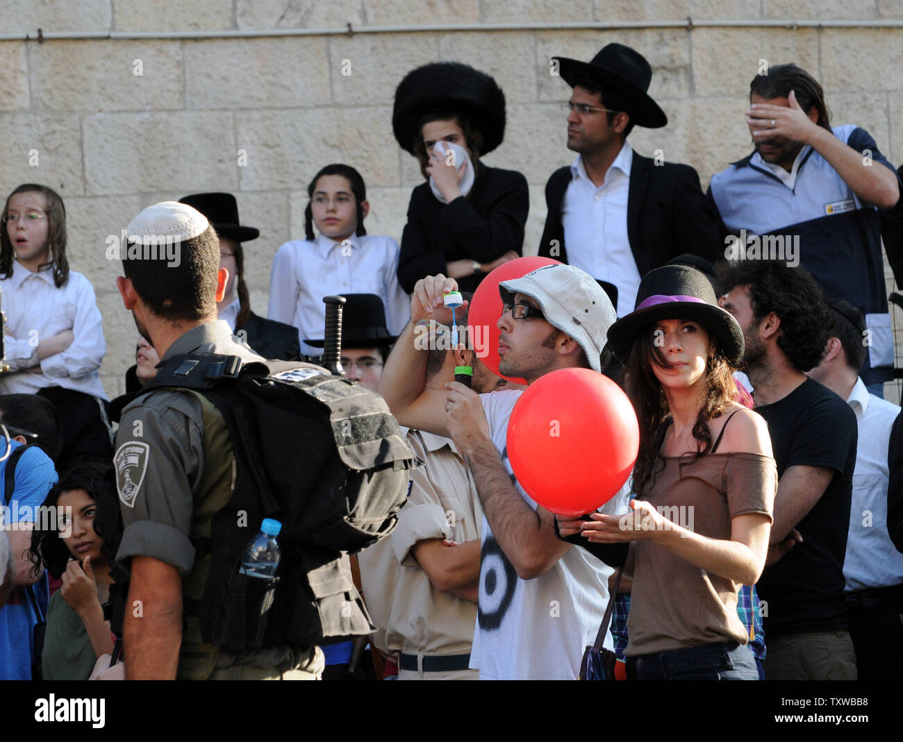 Secular Israelis hold balloons and blow bubbles during an Ultra ...