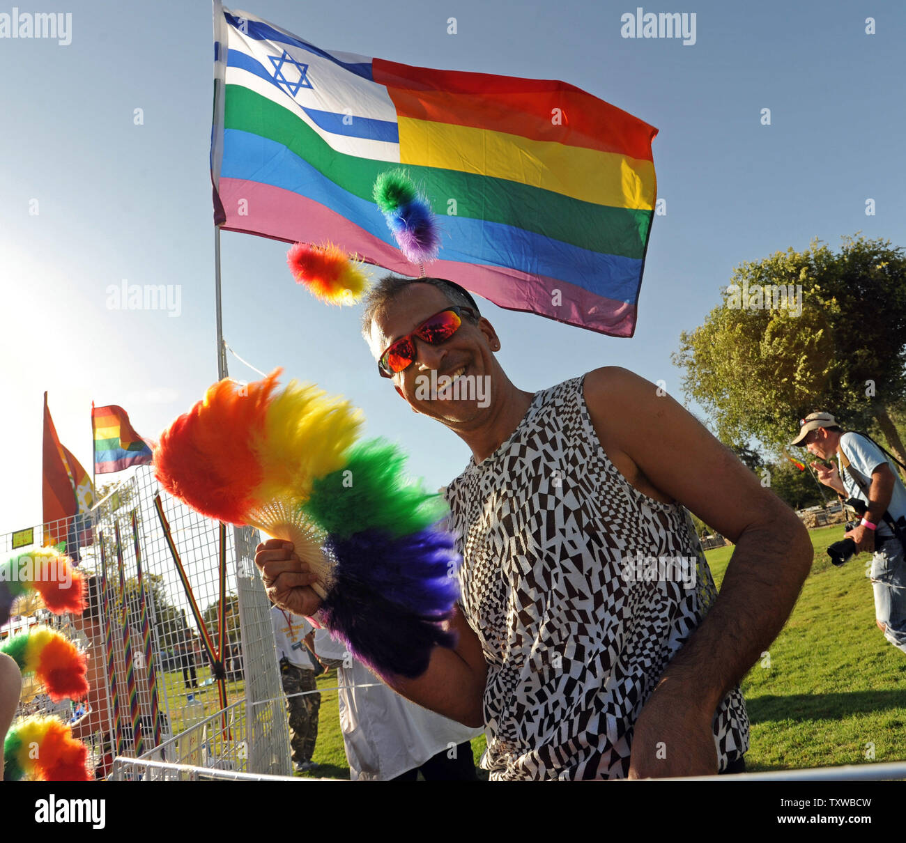 An Israeli stands under a rainbow flag before the annual Jerusalem ...