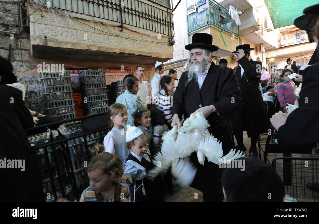 An Ultra-Orthodox Jewish man carries chickens for the Kaparot ceremony ...