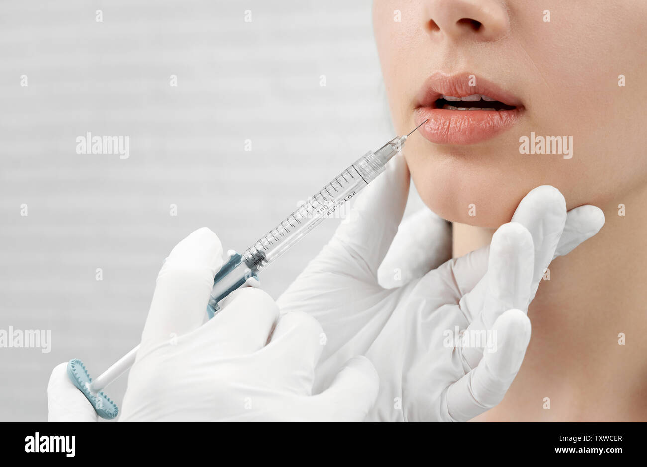 Close up of hands in white rubber medical gloves making injection ...